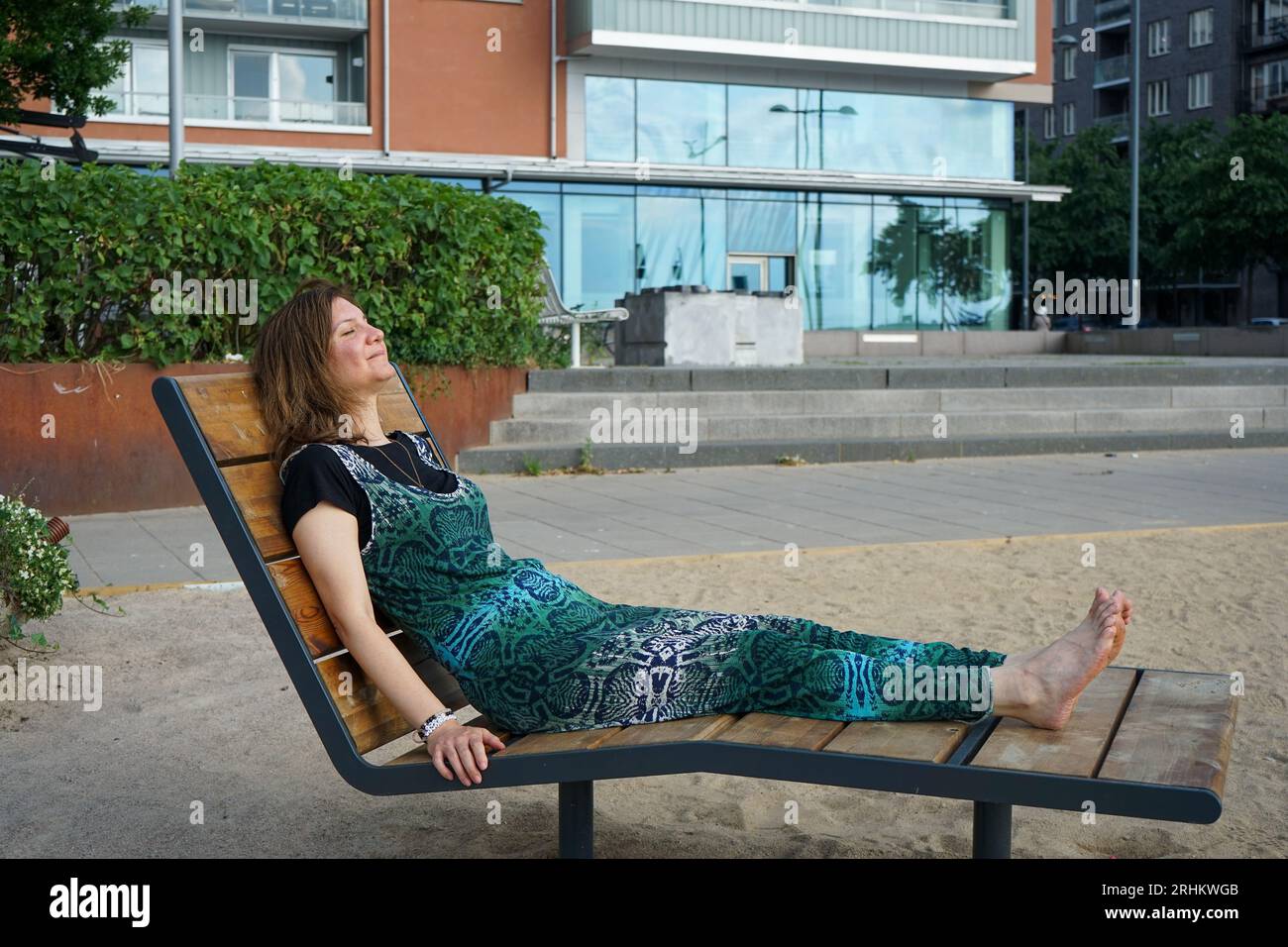 Woman sitting barefoot on a bench in the park hi-res stock photography ...
