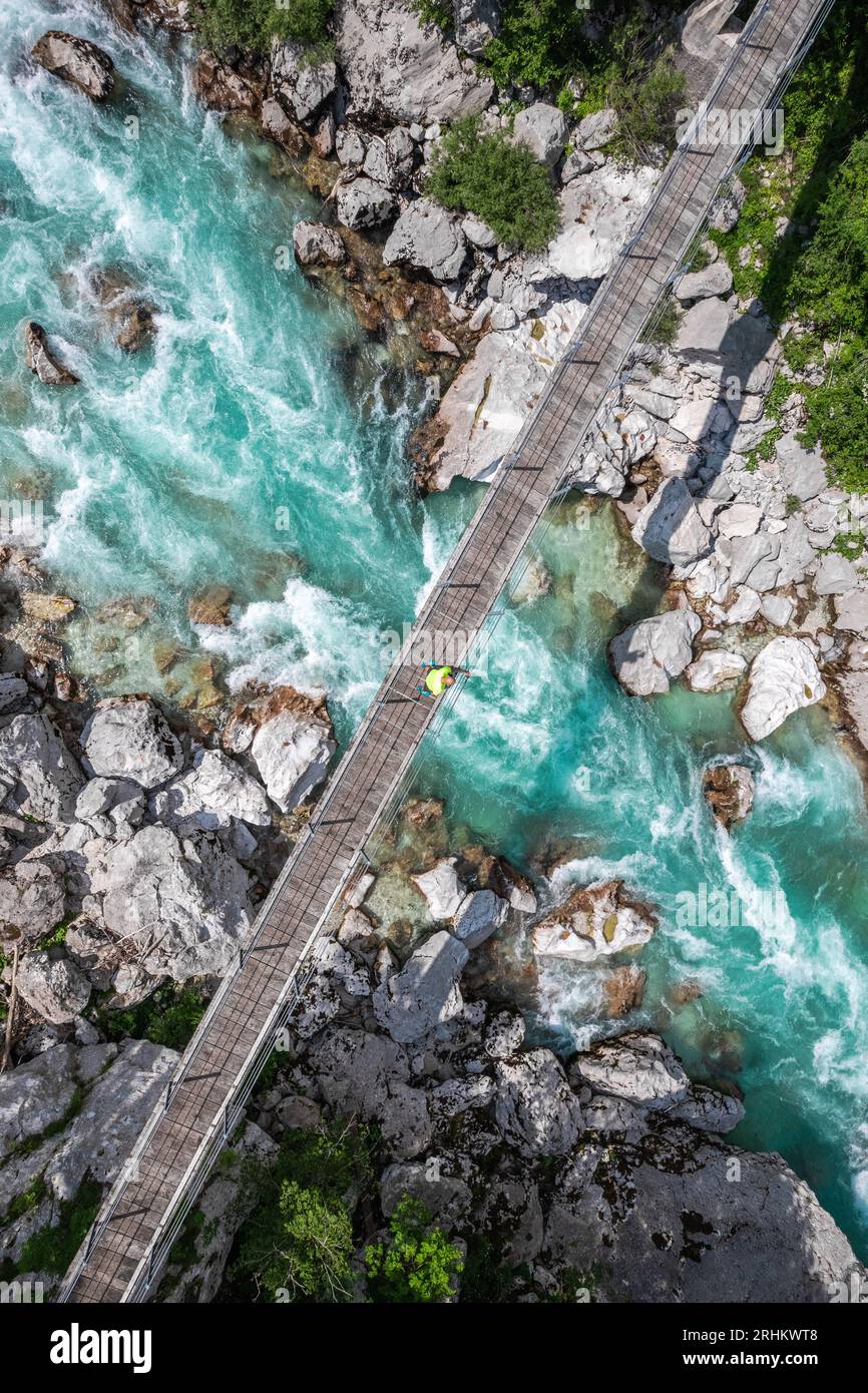 Active man walking over suspension bridge at Soca alpine river in ...