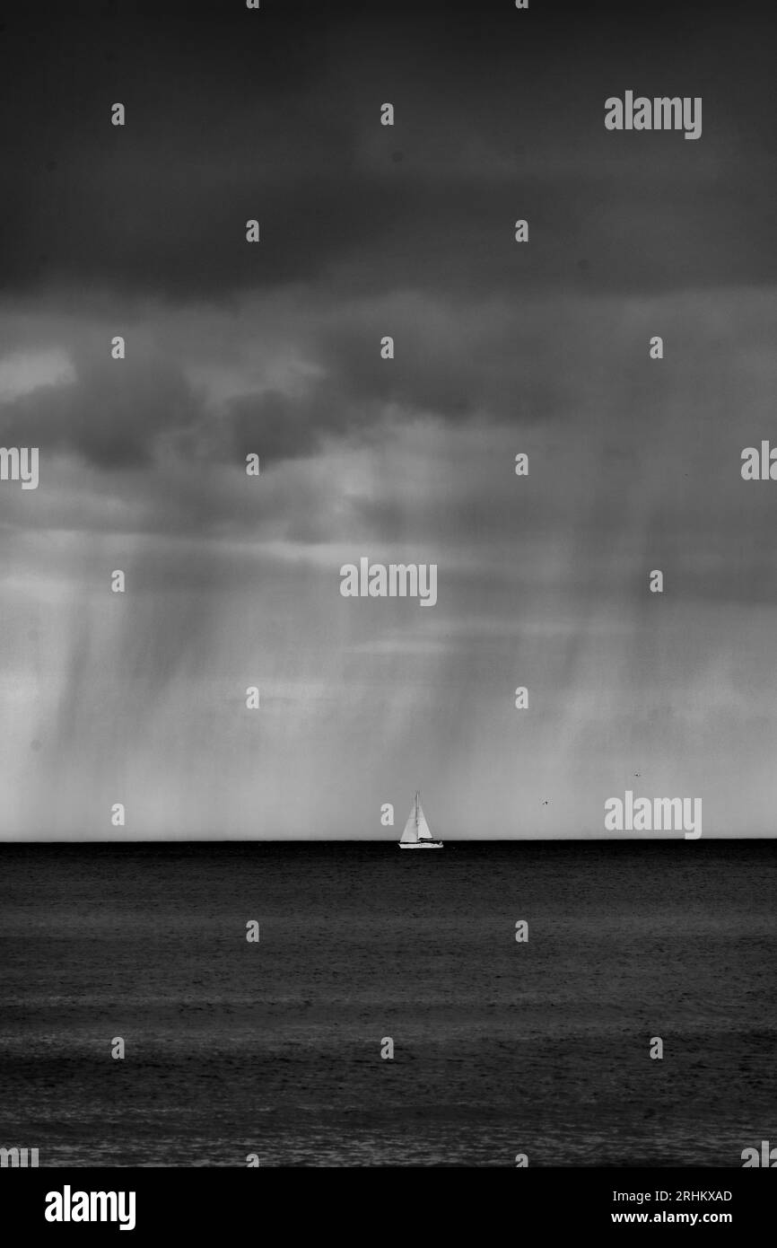 Lone yacht sailing through a North East squall in the North sea off ...