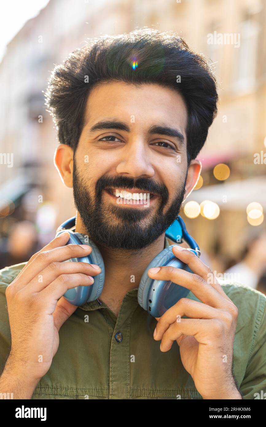 Joyful relaxed overjoyed indian man choosing, listening favorite ...