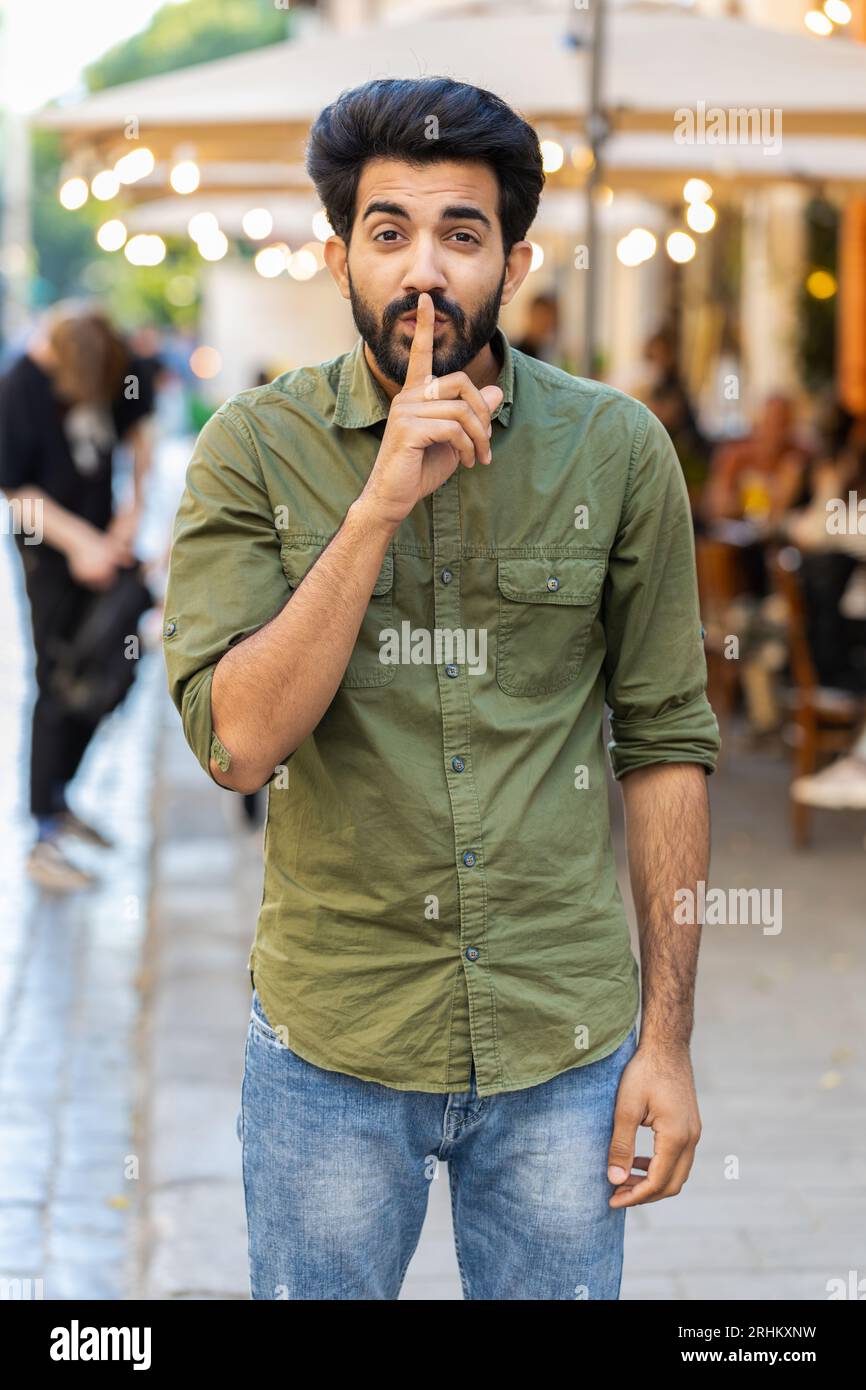 Shh be quiet please. Indian man presses index finger to lips makes ...