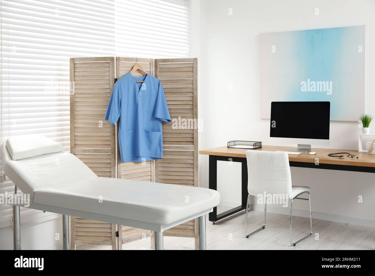 Modern medical office with doctor's workplace and examination table in ...