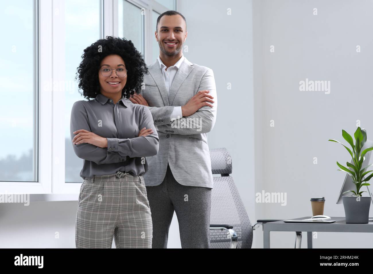 Young smiling colleagues near window in modern office Stock Photo - Alamy