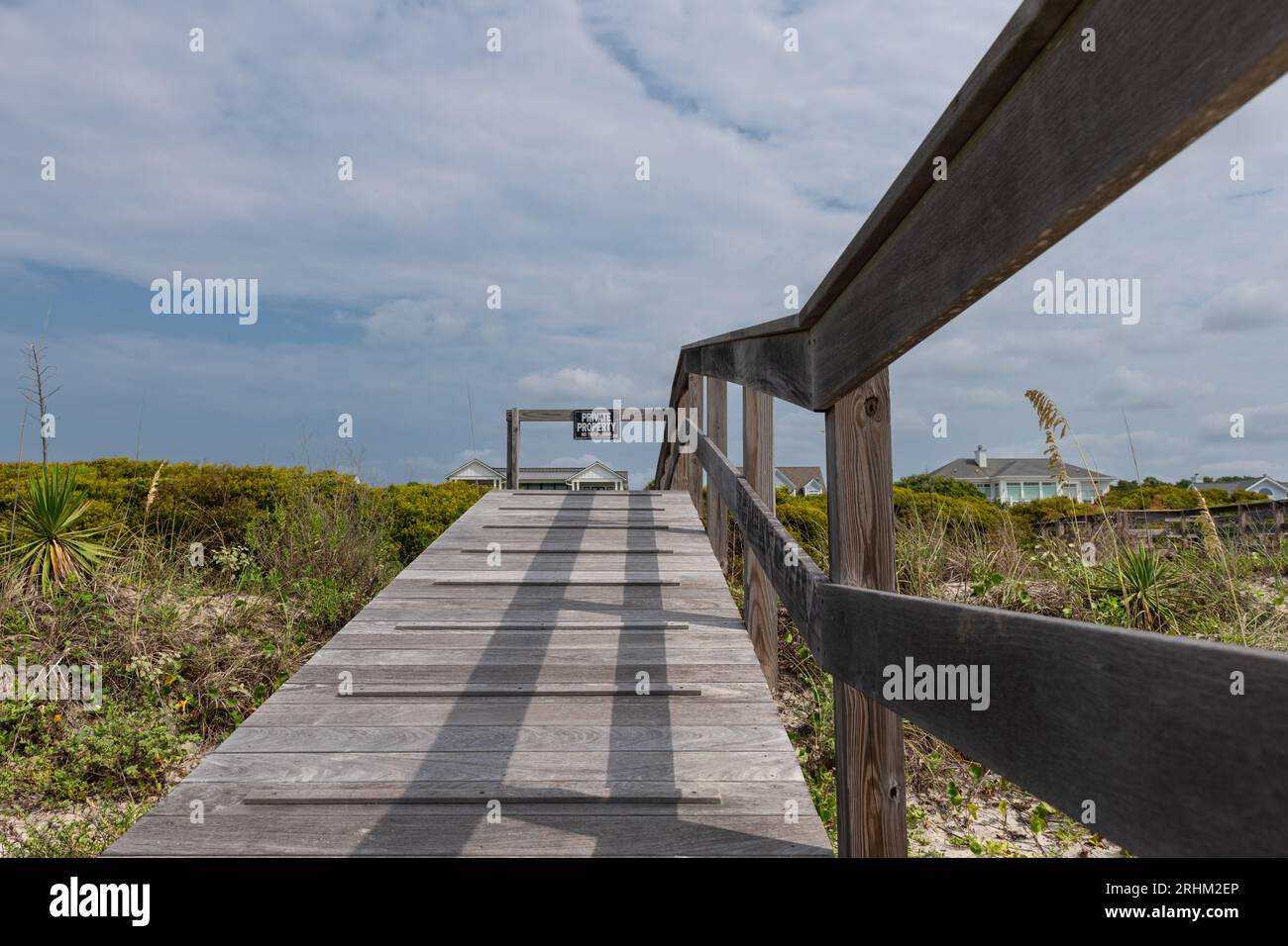 Wooden boardwalk from the beach to vacation home with private property ...
