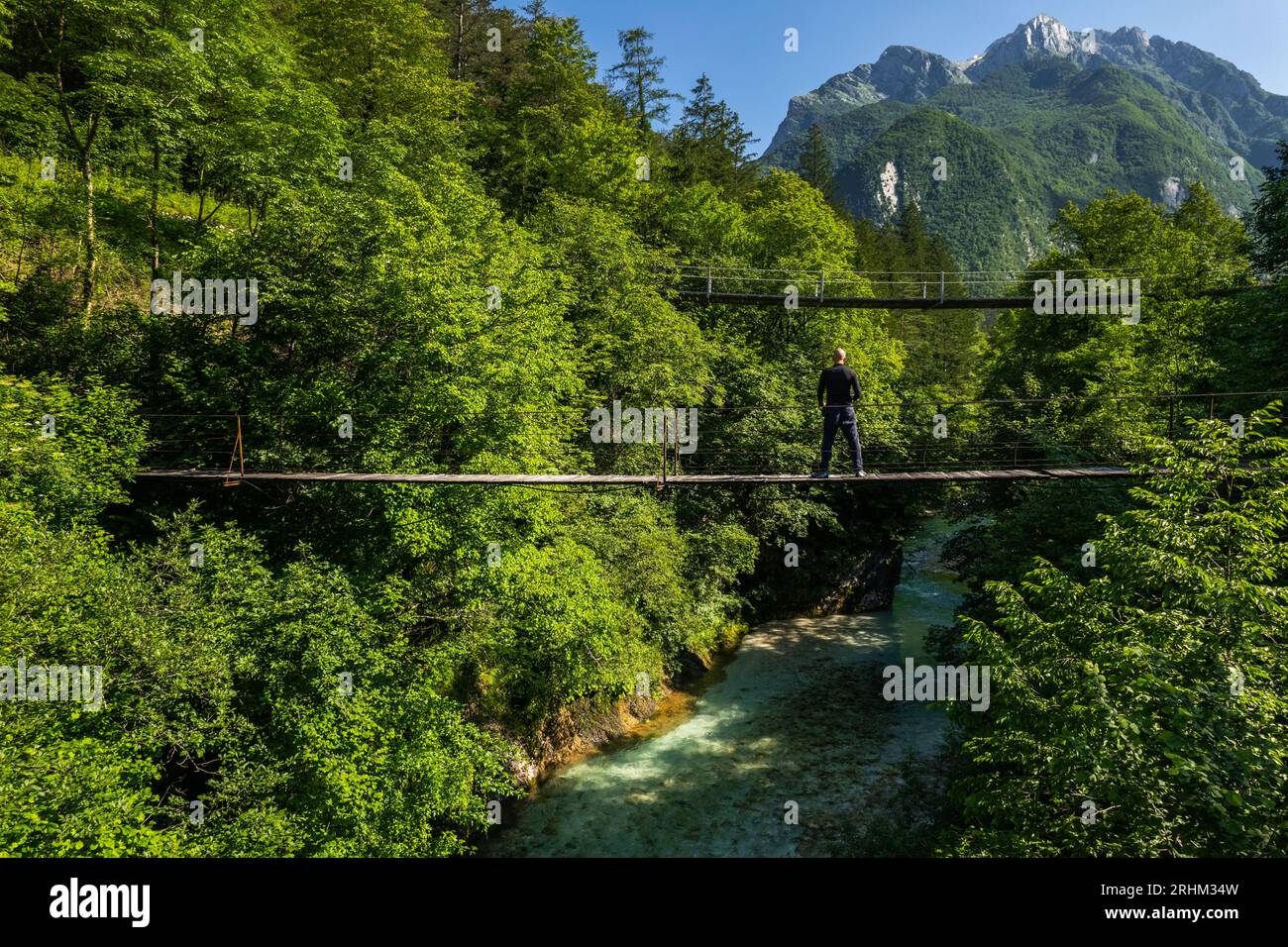 Active young man walking over suspension bridge in mountains Stock ...