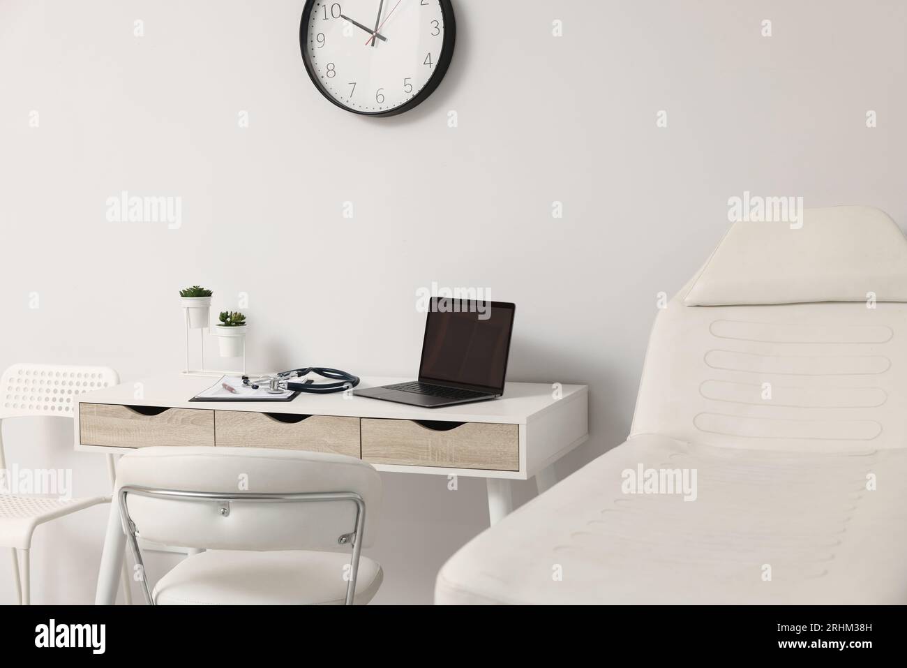 Modern medical office with doctor's workplace and examination table in ...