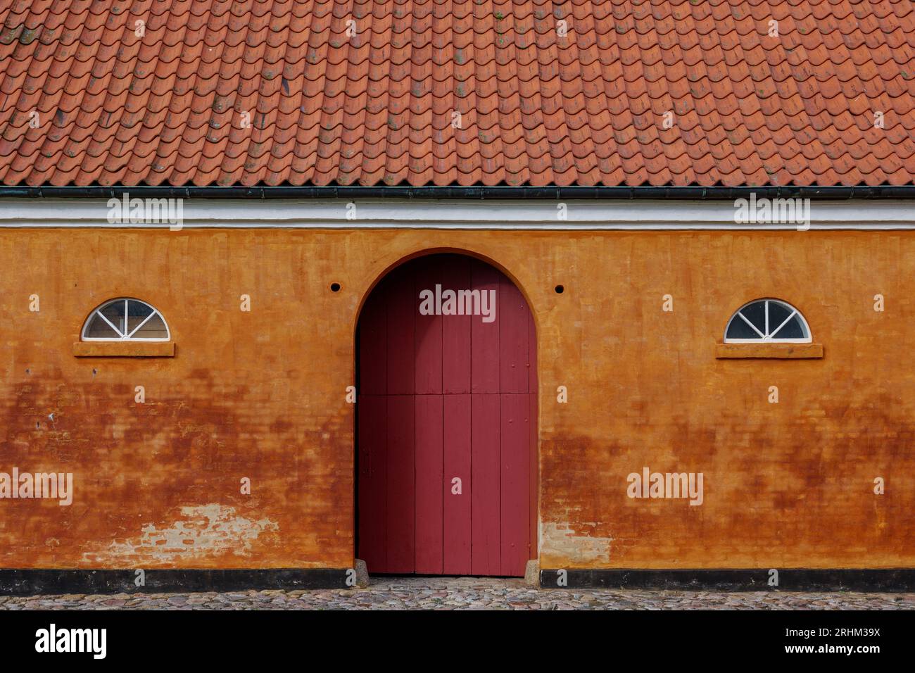 Exterior symmetric front view of old orange stucco wall with single ...