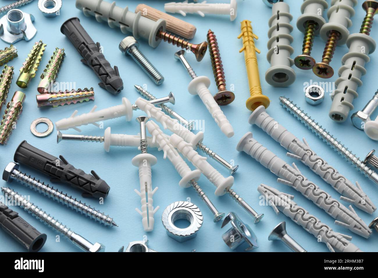 Many different fasteners and dowels on light blue background, above ...