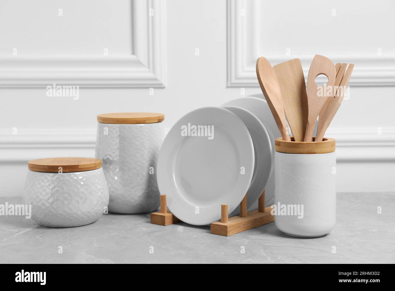 Set of different kitchenware on light gray table near white wall Stock ...