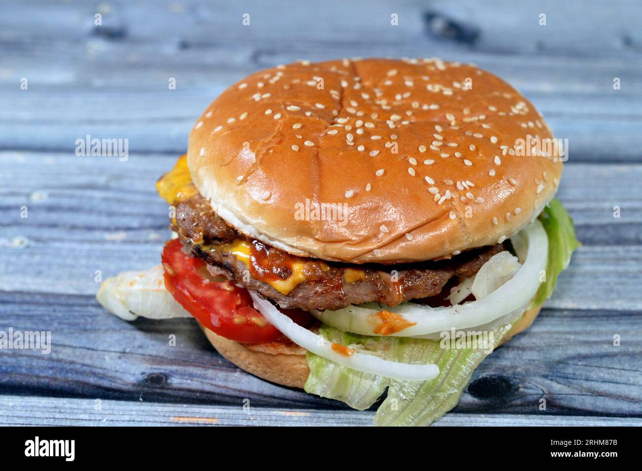 A juicy thick double beef patty with cheese covered with sauce, crispy ...