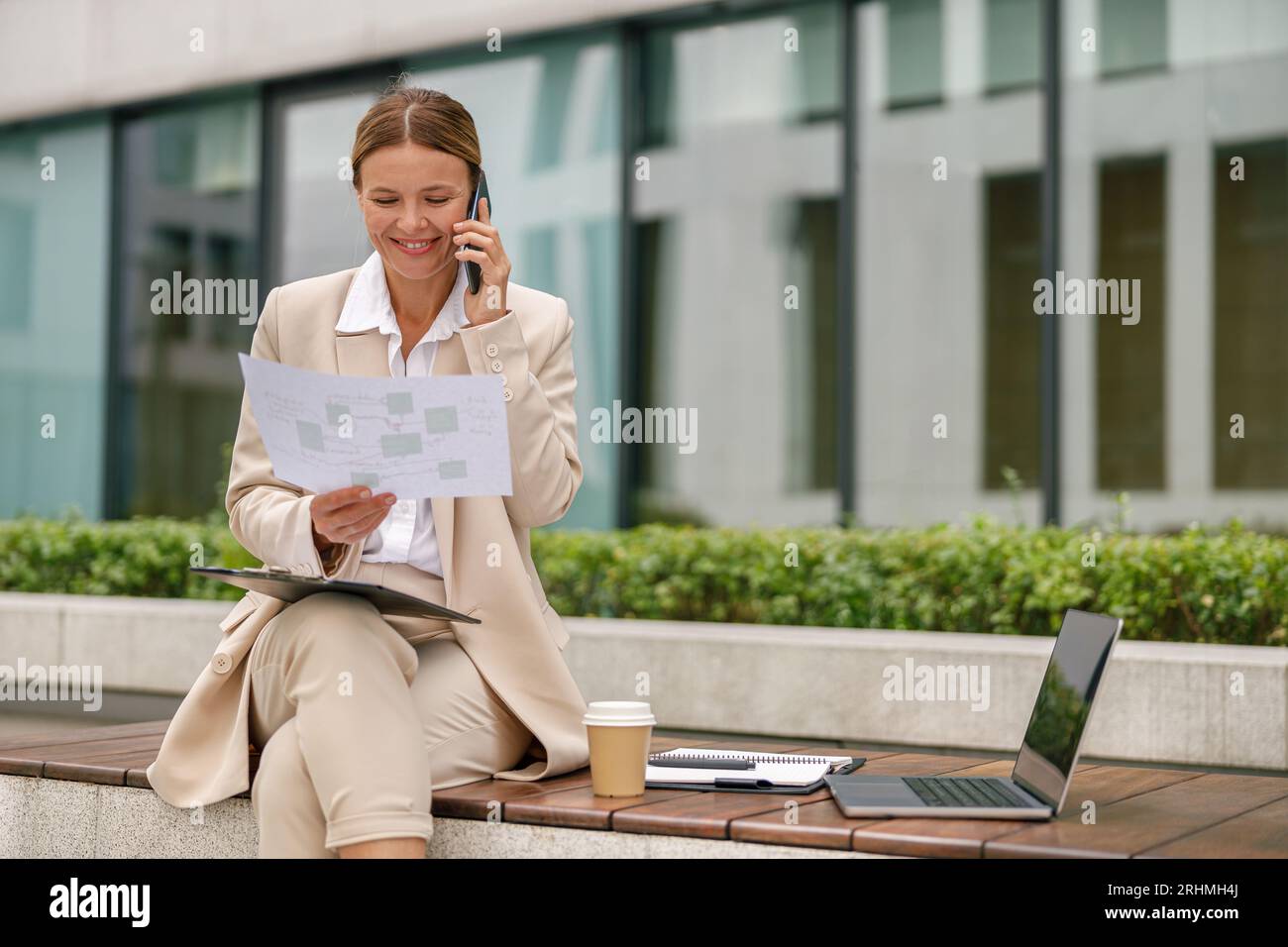 Stylish woman manager talking with client while working with documents ...