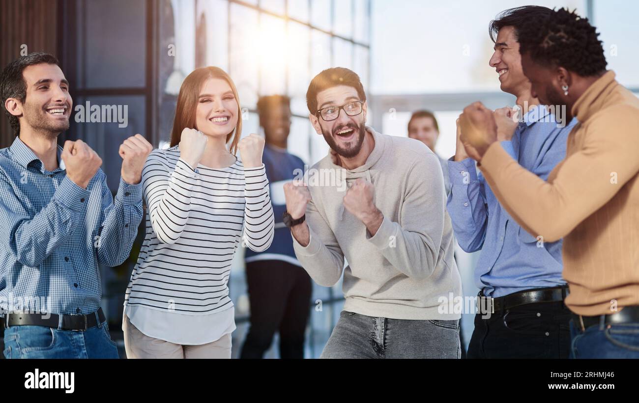 Business people celebrates and clench their fists in the air as a ...