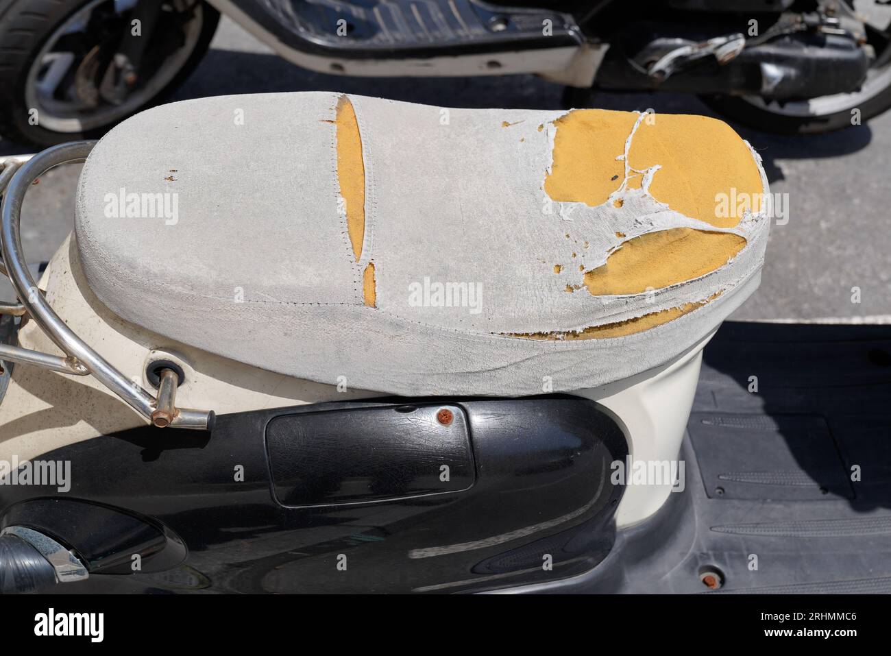 torn and worn saddle old broken scooter parked in the street weathered ...