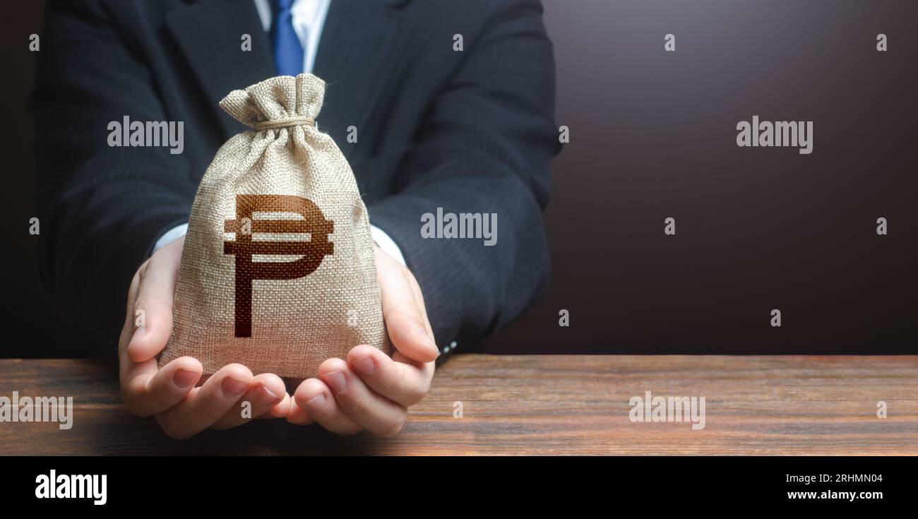 Businessman holds out philippine peso money bag. Getting a grant ...