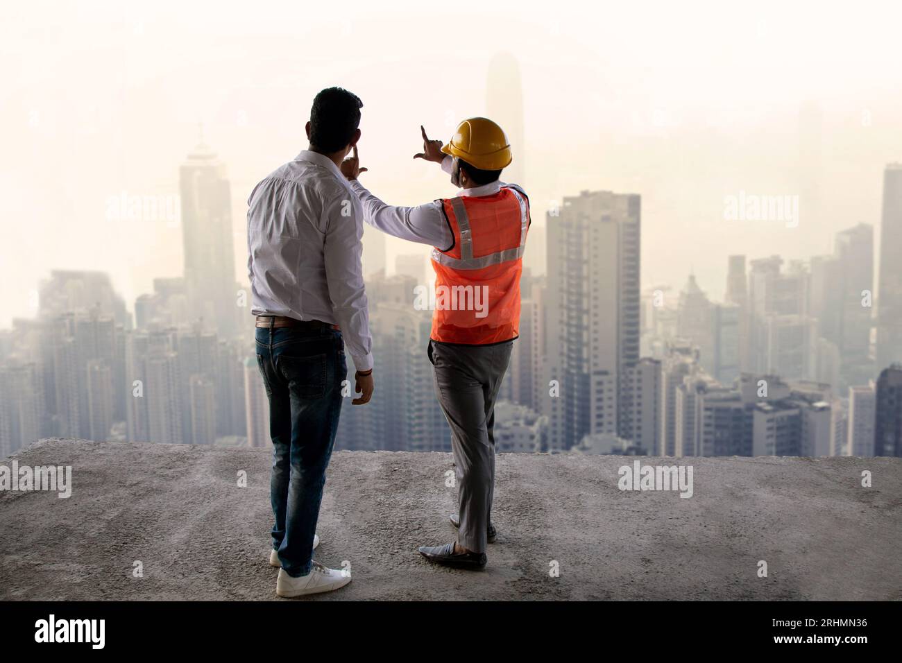 Back view of two Indian male engineer and architect wearing helmet and ...
