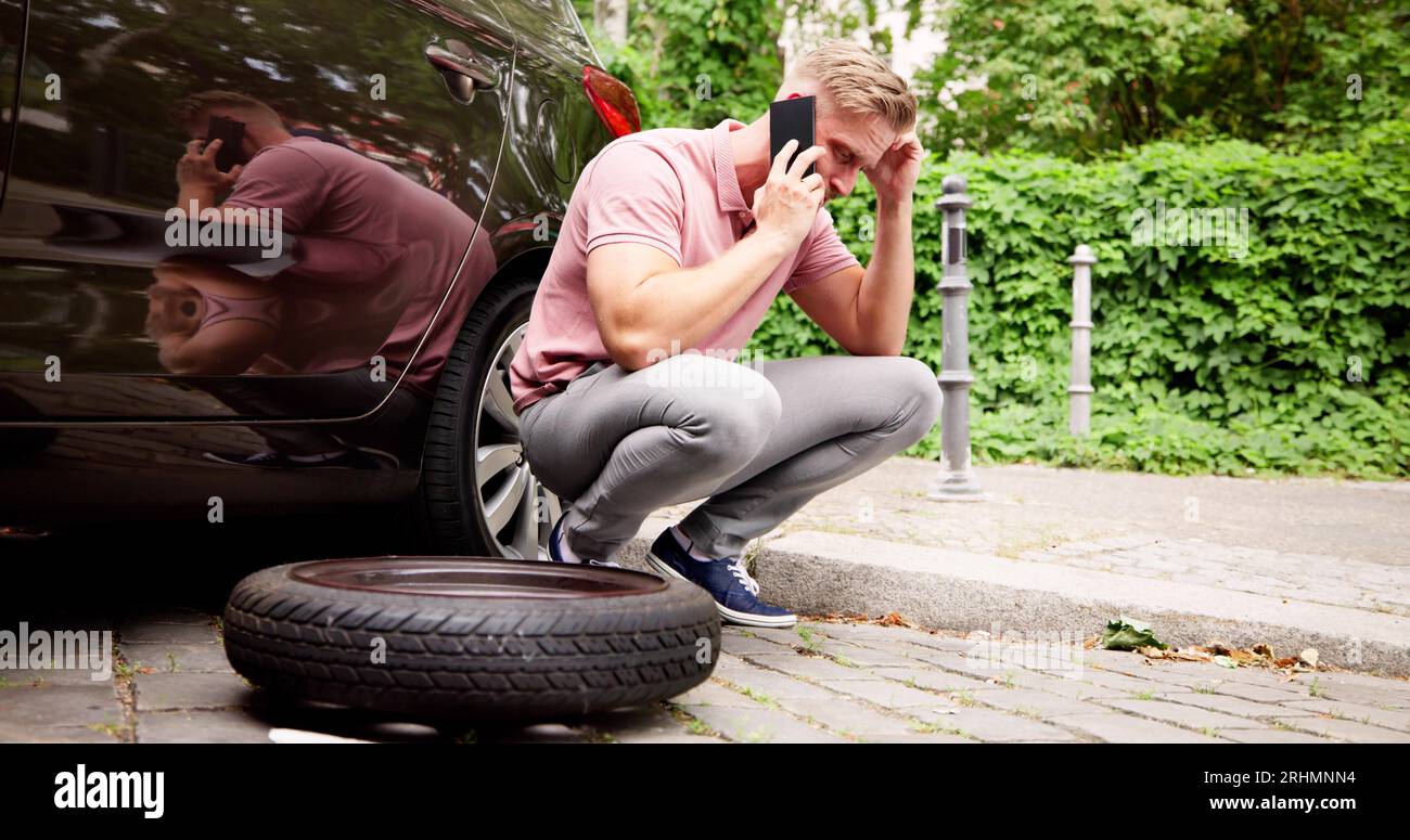 Car With Flat Tire. Man Calling On Phone Stock Photo - Alamy