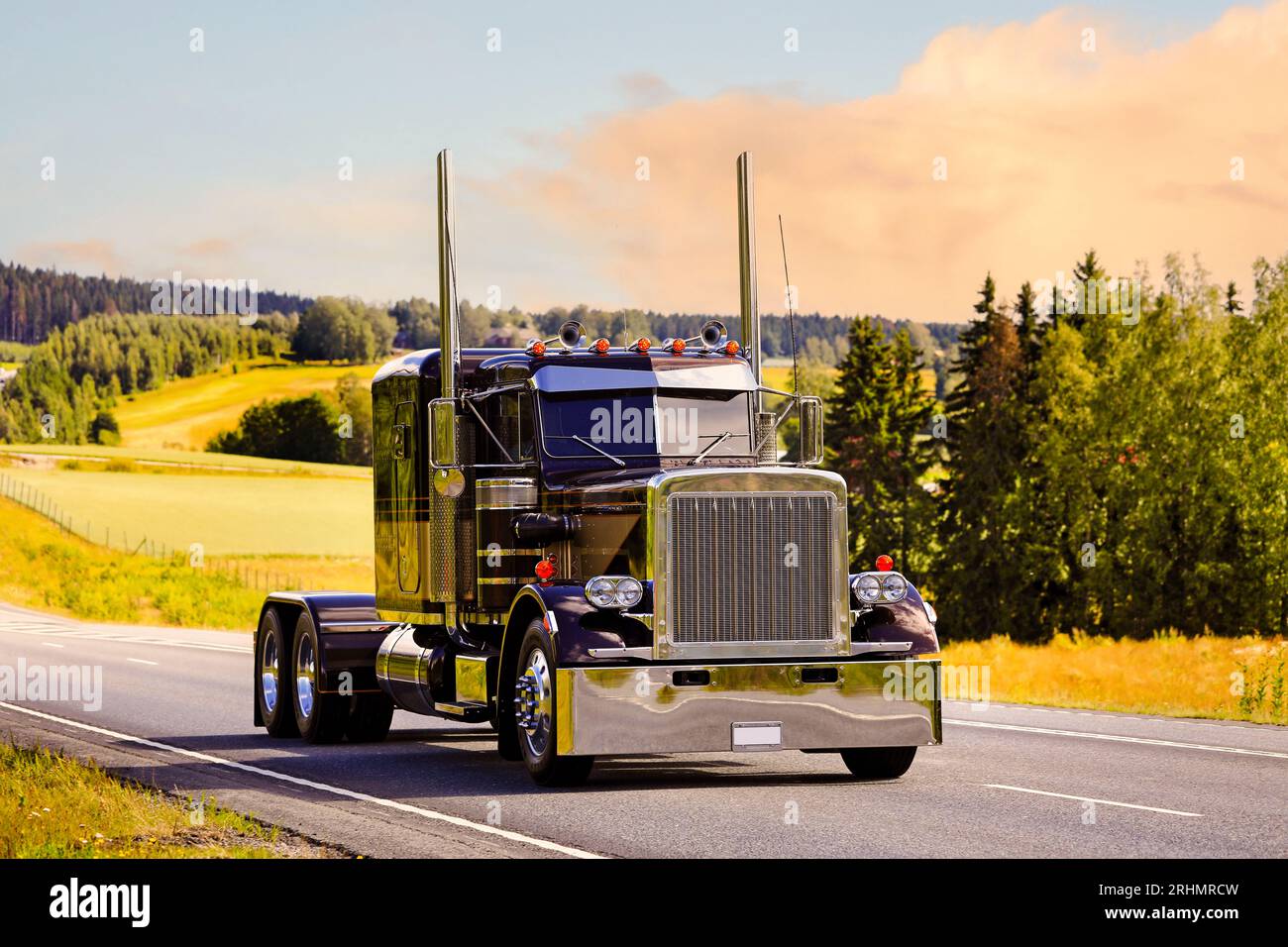 Beautiful classic American truck trucking along highway under golden ...