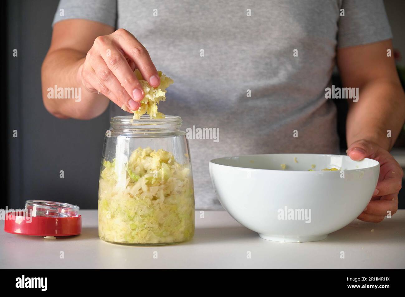 Man hands putting cabbage into the fermentation jar to prepare ...