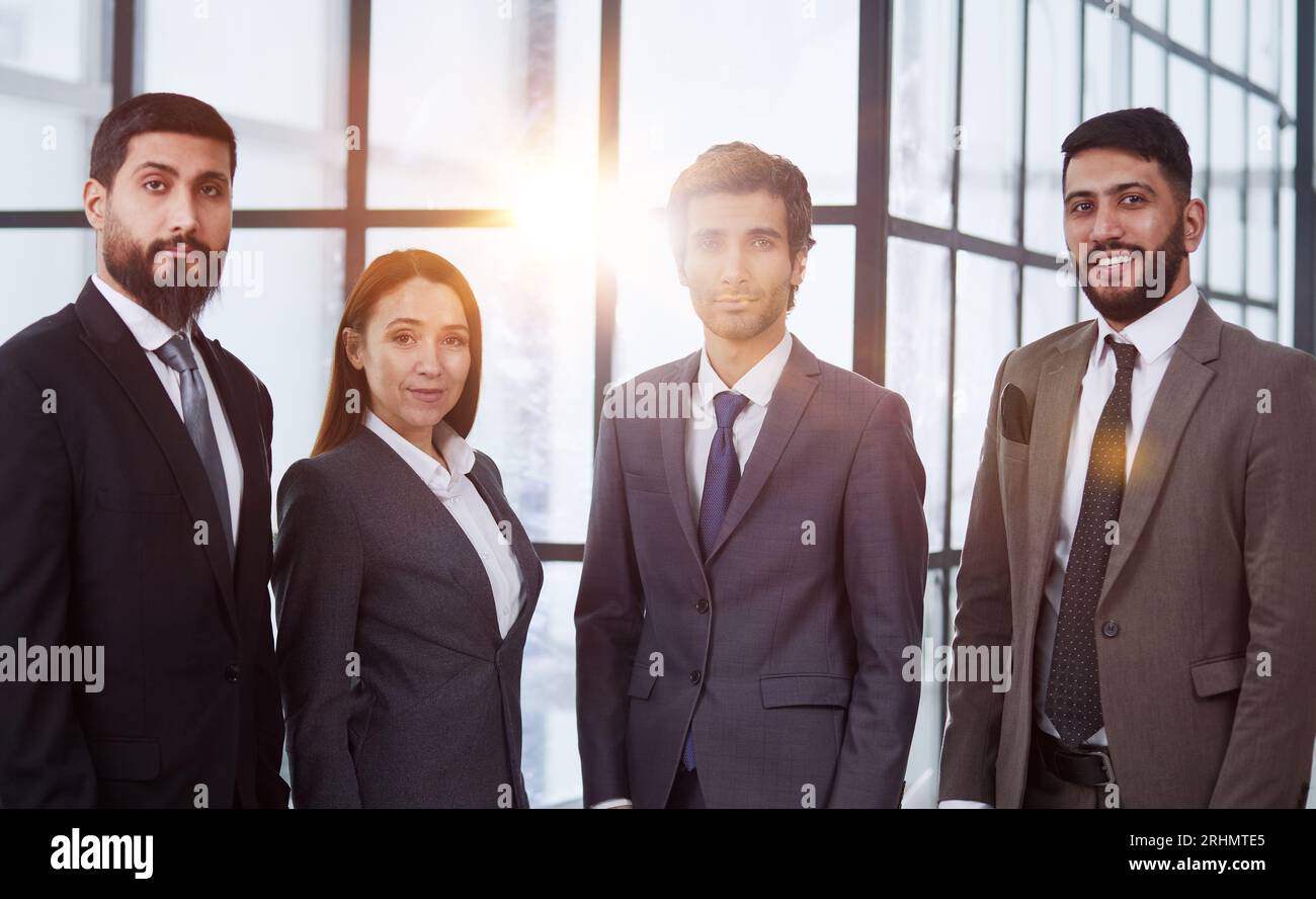 Businessmen with brunette in group posing in office lobby Stock Photo ...