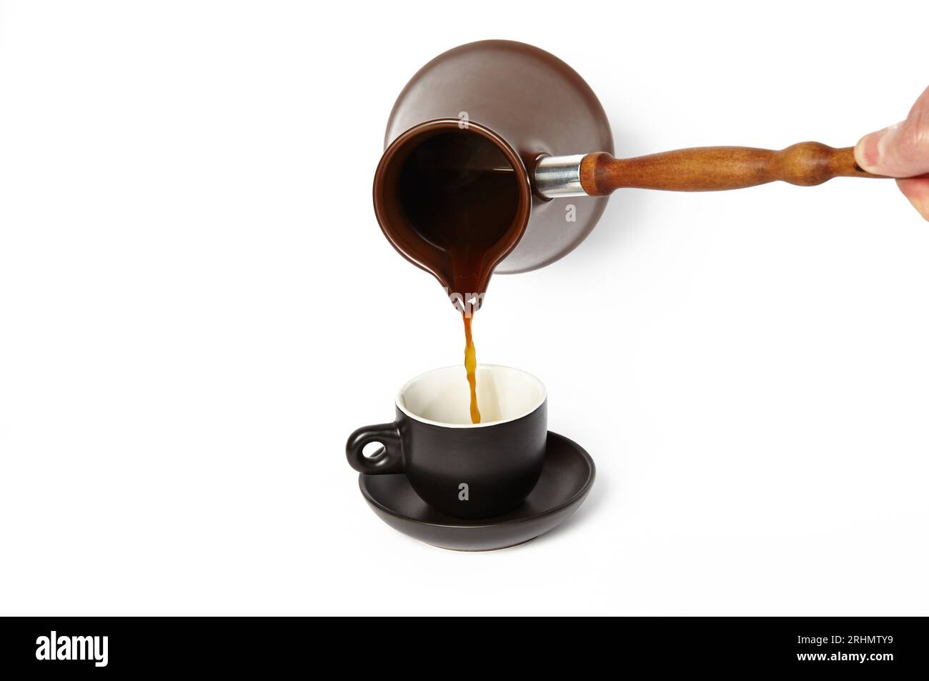 Man pouring coffee into cup isolated white background. Clay cezve for ...