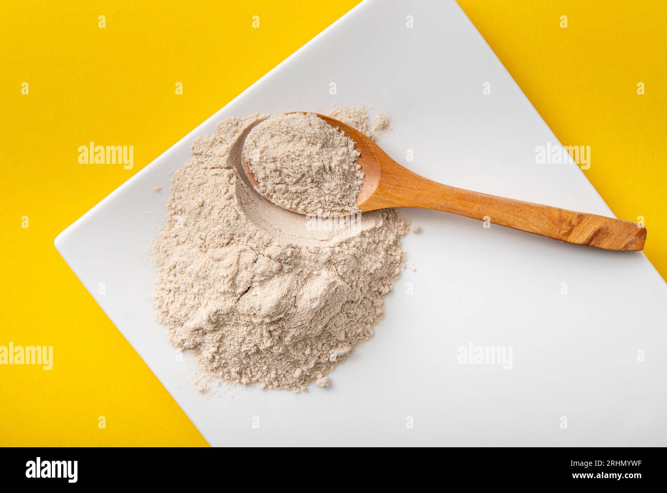 Psyllium husk flour powder on white plate and wooden spoon indoors at ...