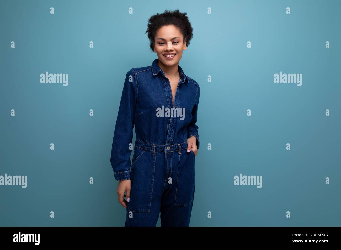 a young woman with dark skin and black hair is dressed in a blue genim ...
