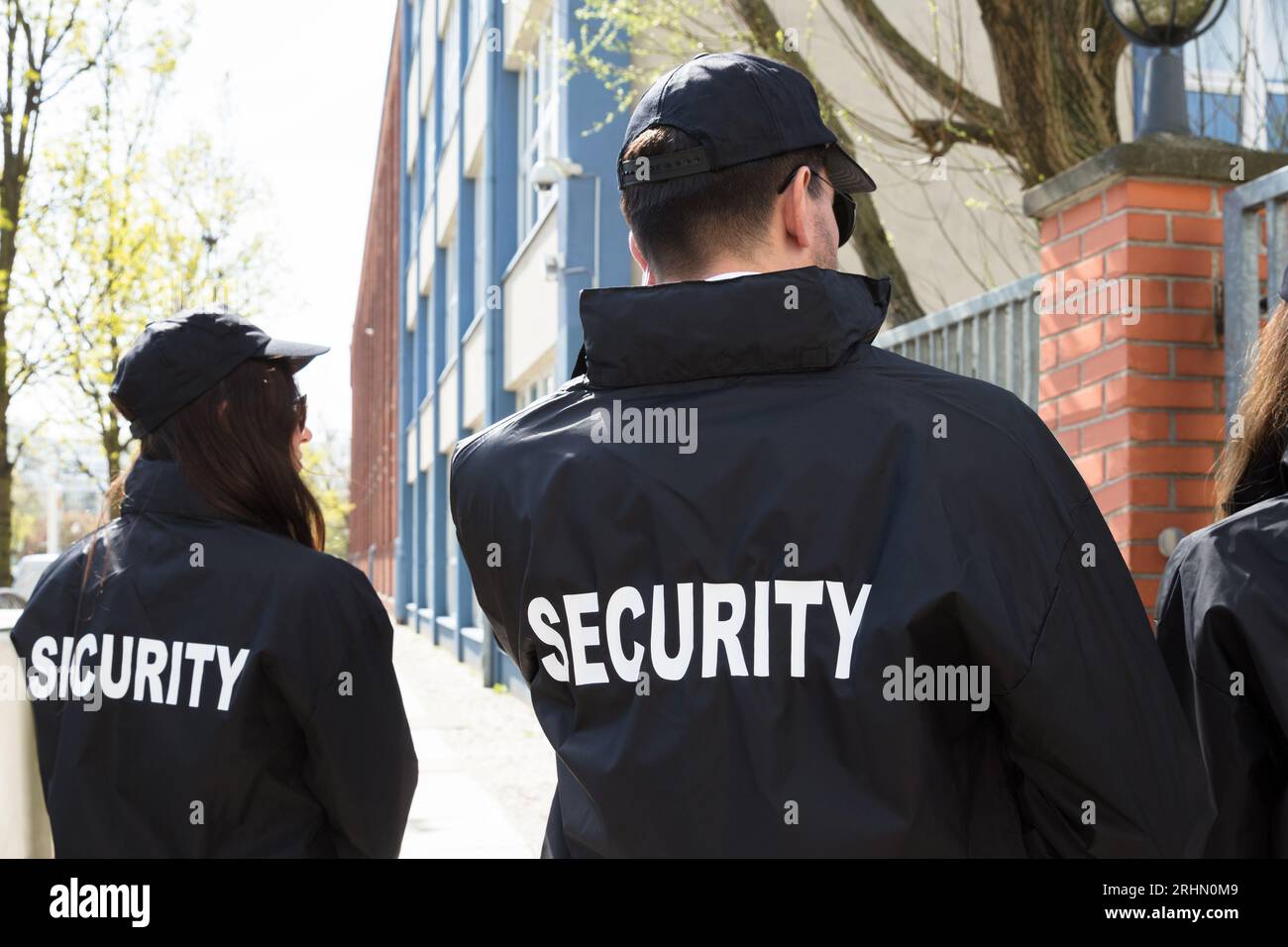 Rear View Of Security Guards In Black Uniform Standing Outside Building ...