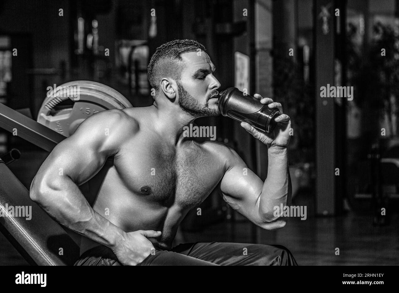 Man at gym and holding bottle of water. Lifestyle portrait of handsome ...