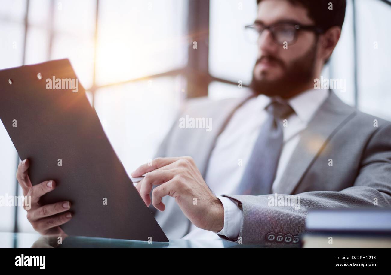 Businessman sitting at office desk signing a contract with shallow ...