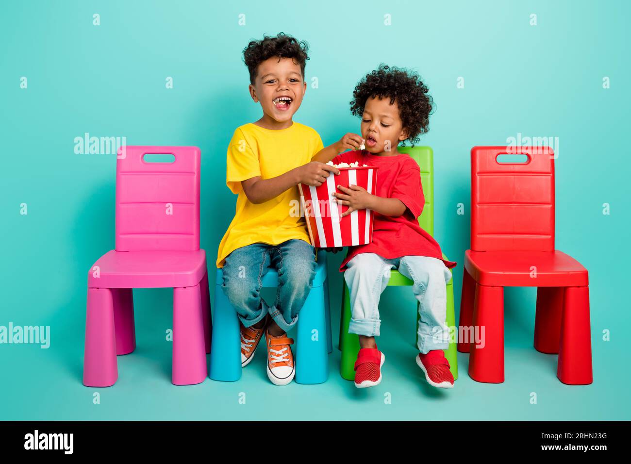 Full size photo of two adorable small boys sitting chairs eating ...
