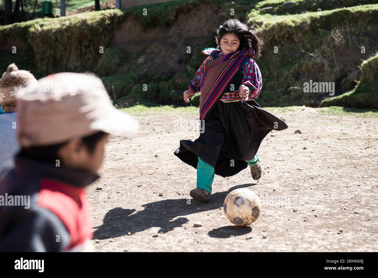 Peruvian girl with colorful clothes playing soccer Stock Photo - Alamy