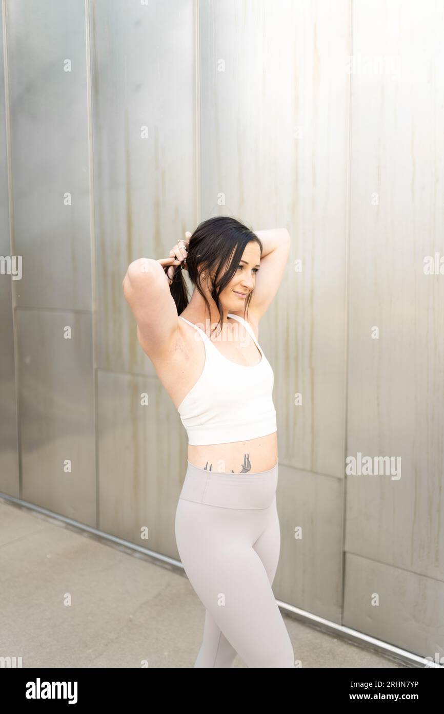 Woman tying back her hair hi-res stock photography and images - Alamy