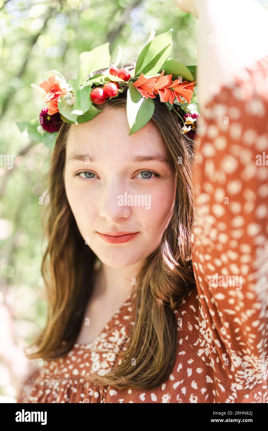 A woman with a flower crown grabbing a tree branch Stock Photo - Alamy
