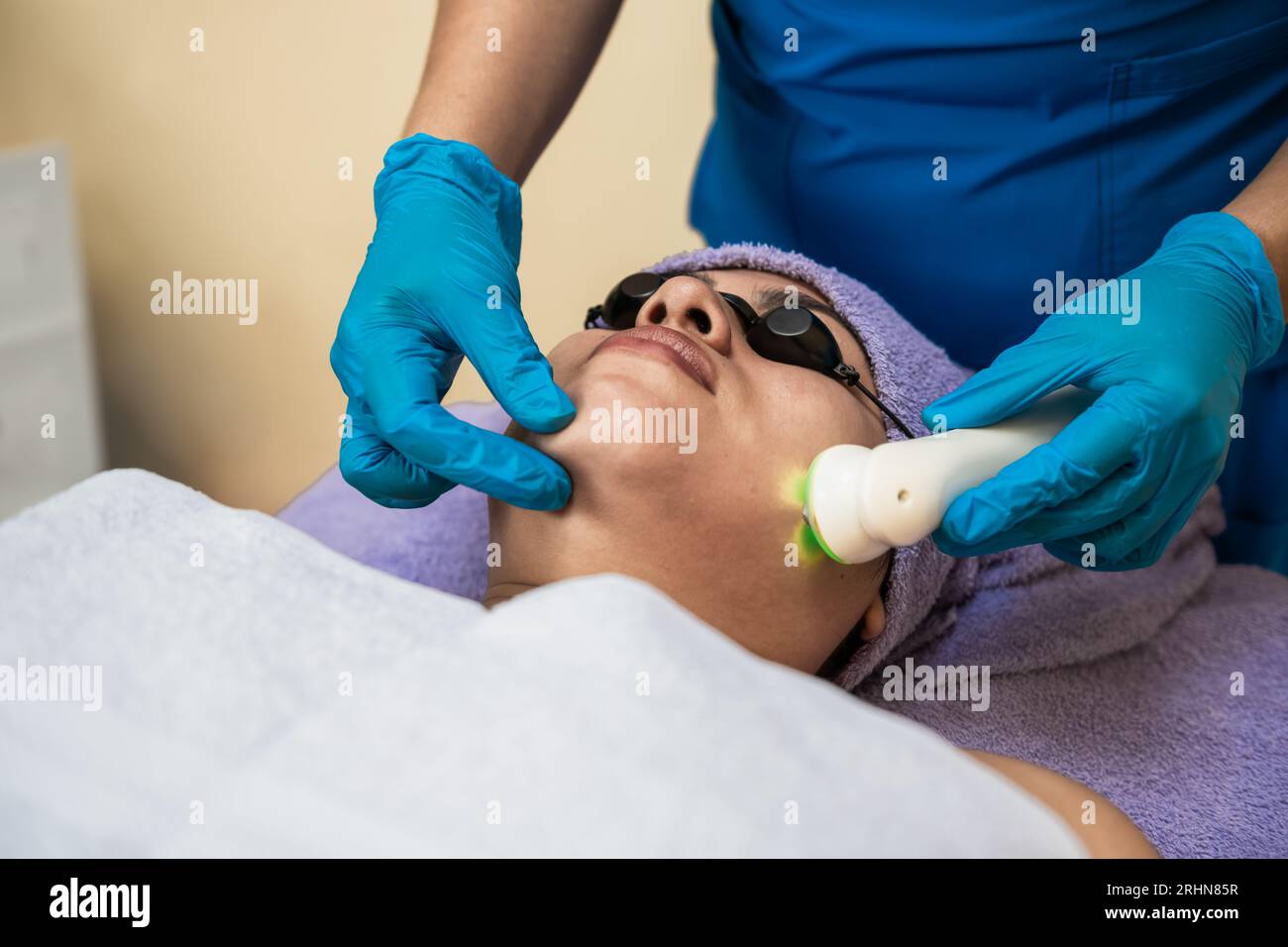 Latin woman doing a facial with dermapen and dermaplaning techniques ...
