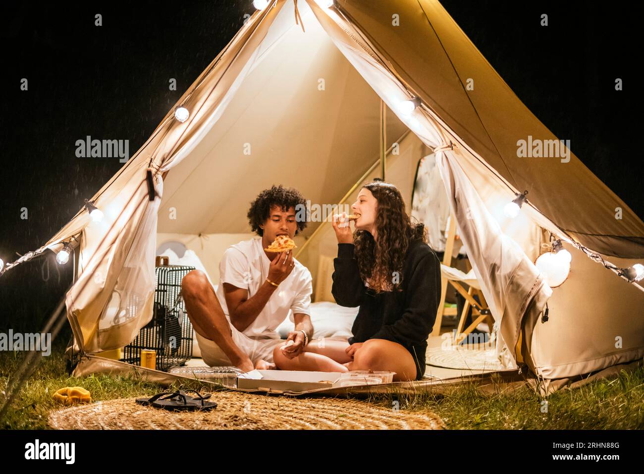 couple in love eating pizza in a camping tent Stock Photo - Alamy