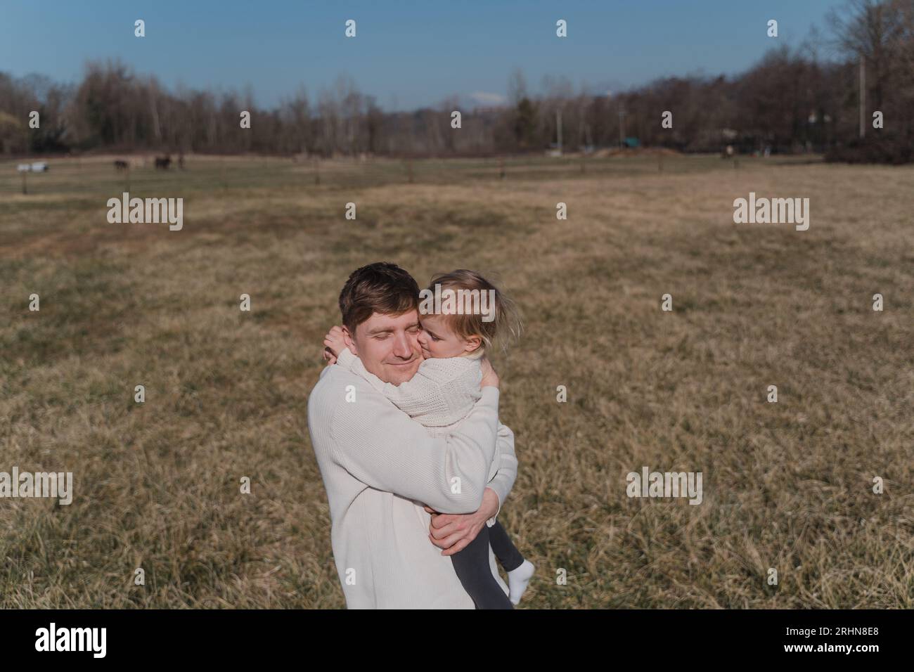 A man tightly hugs a small child in a dry field Stock Photo - Alamy