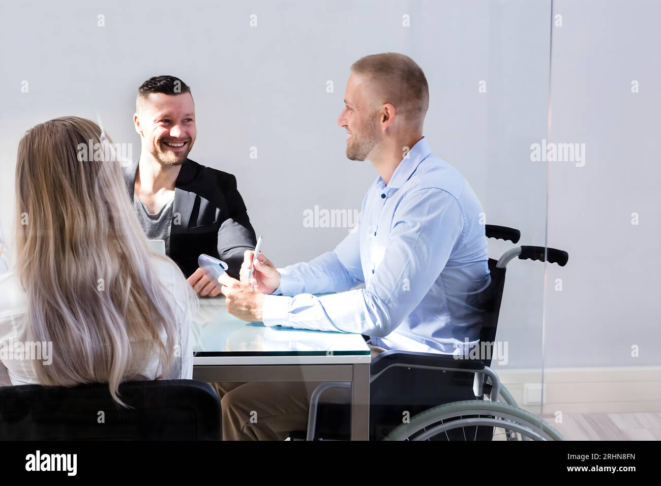 Disabled Male Manager Sitting With His Colleagues At Workplace Stock ...