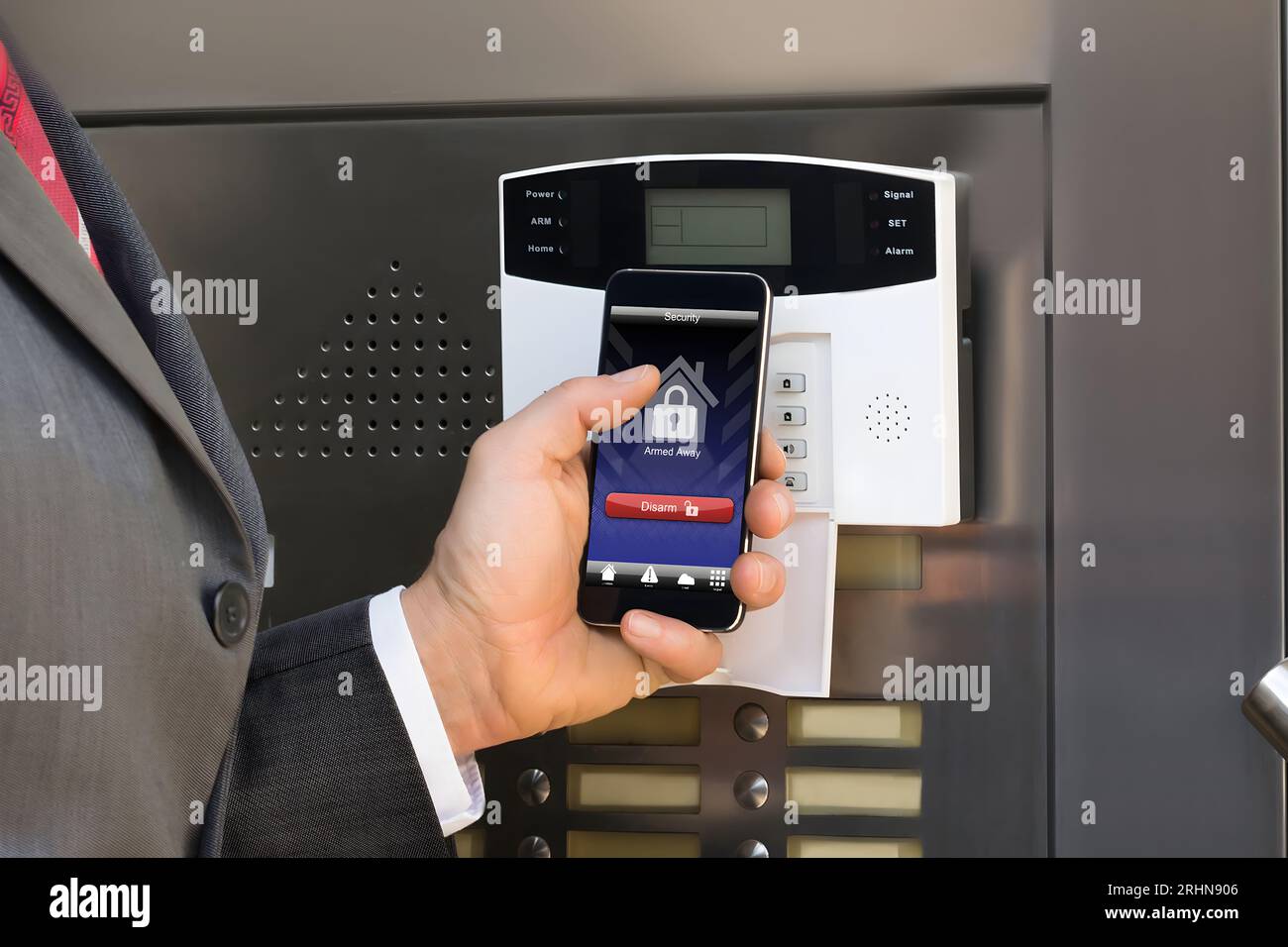 Mature Businessman Holding Smartphone For Disarming Security System Of ...