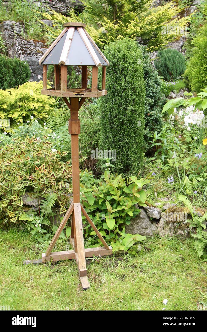 A Tall Wooden Bird Feeding Table in a Garden Setting Stock Photo - Alamy