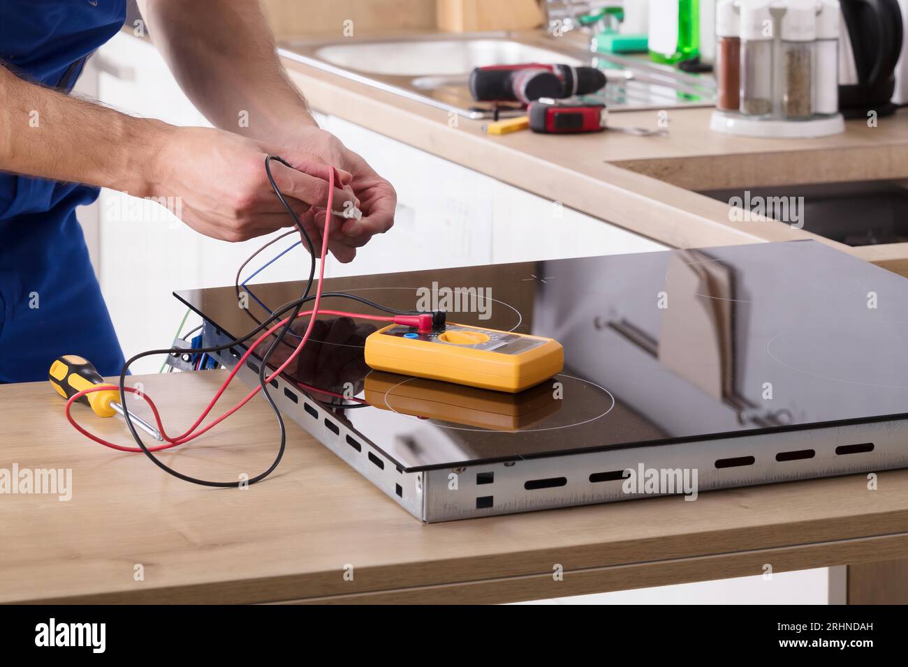 Male Technician Repairing Induction Stove With Digital Multimeter In ...