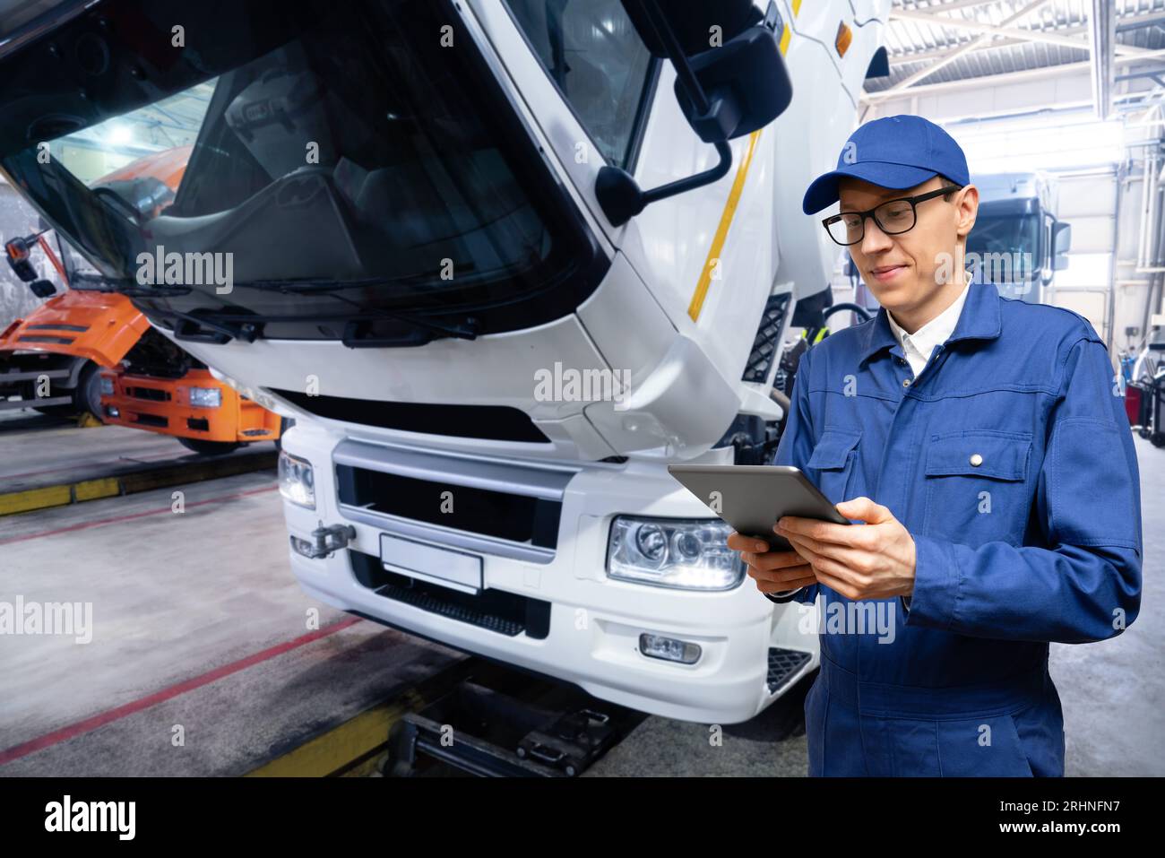 Serviceman with digital tablet on the background of the truck in the ...