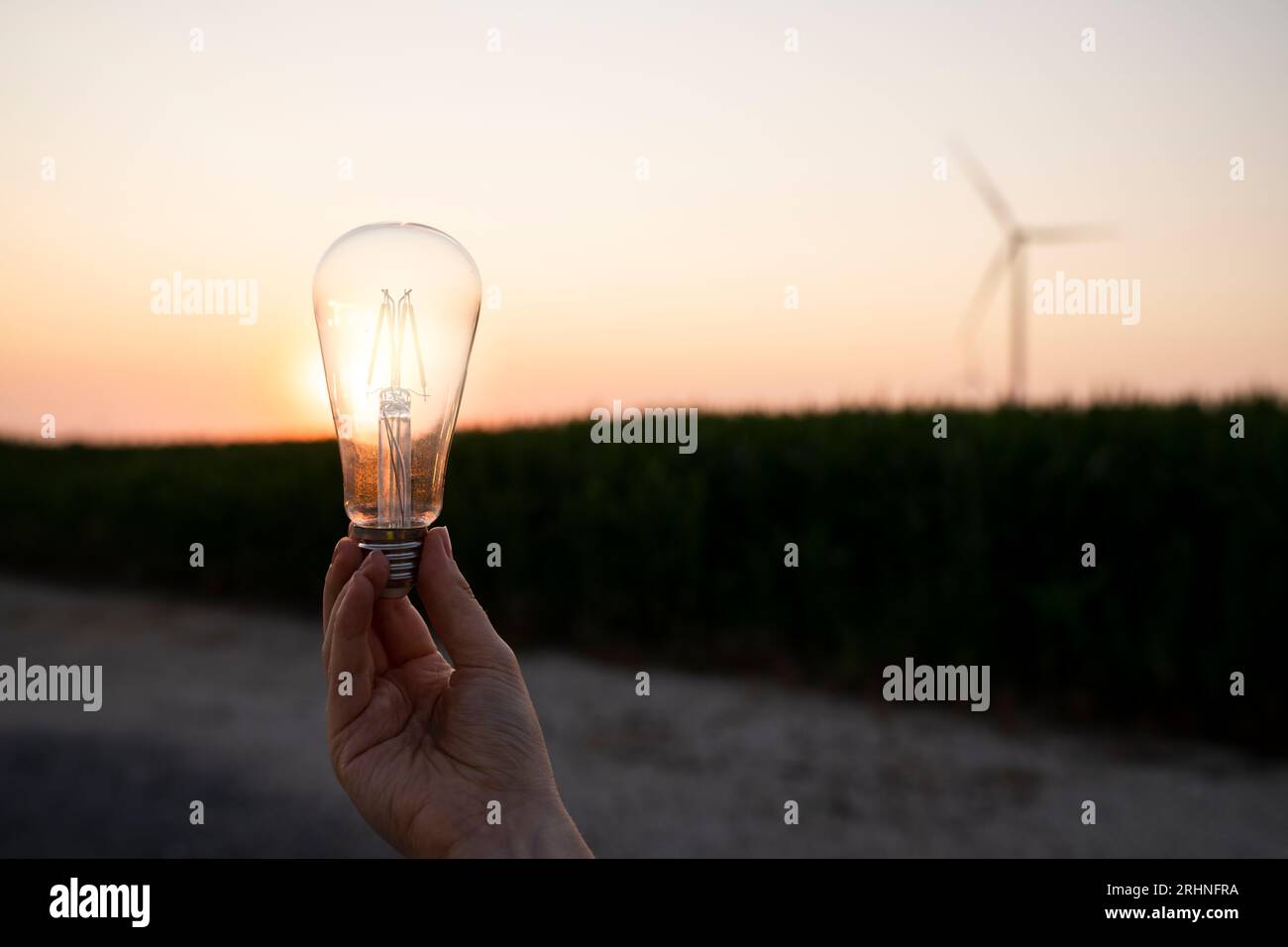 Close up of electric lamp in the hand on the backgoriun of a sunset ...