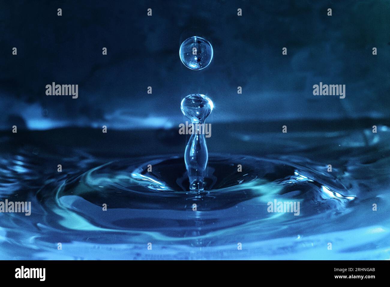 Close up of water drop falling into a sink full of clear and pure water ...