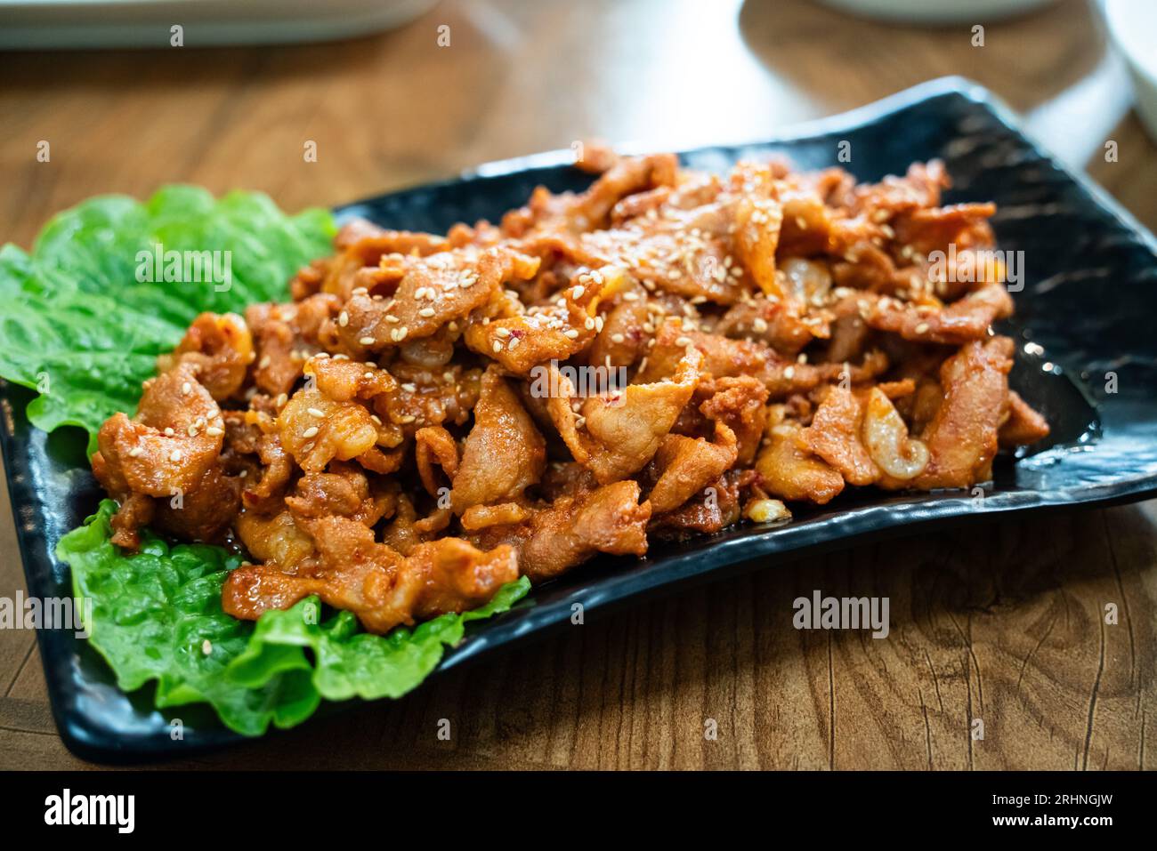 Delicious Korean cuisine jeyuk bokkeum, stir-fried pork in a plate for ...