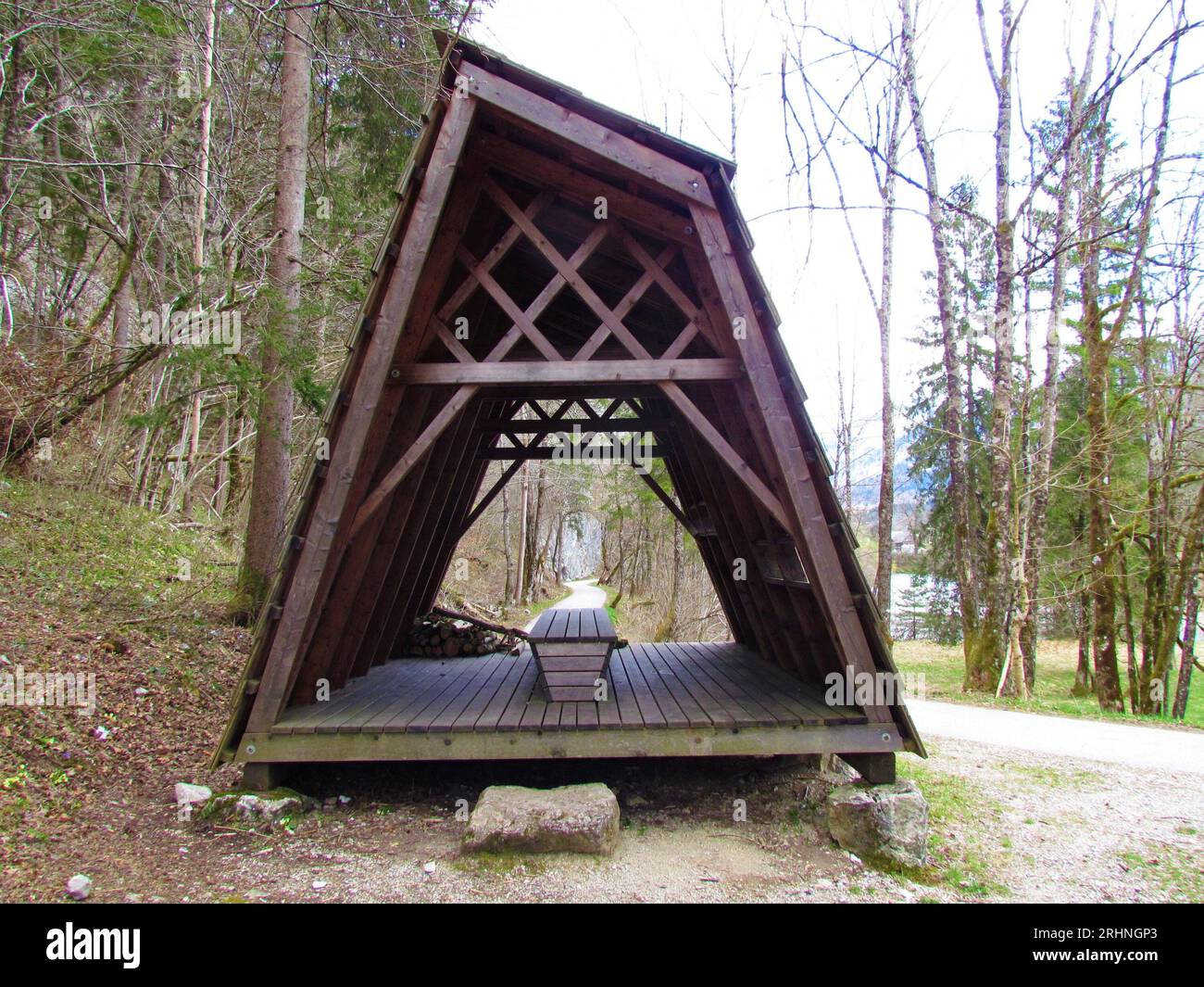 View of wooden shelter building with benches and a narrow path leading ...