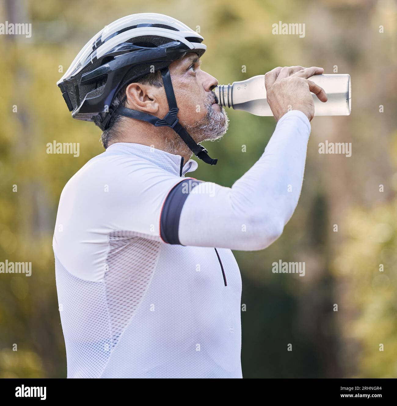 Cycling, fitness and senior man drinking water in park for hydration ...