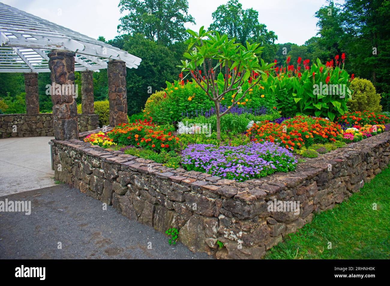 A variety of colorful flowers in a stone flower bed at the end of the ...