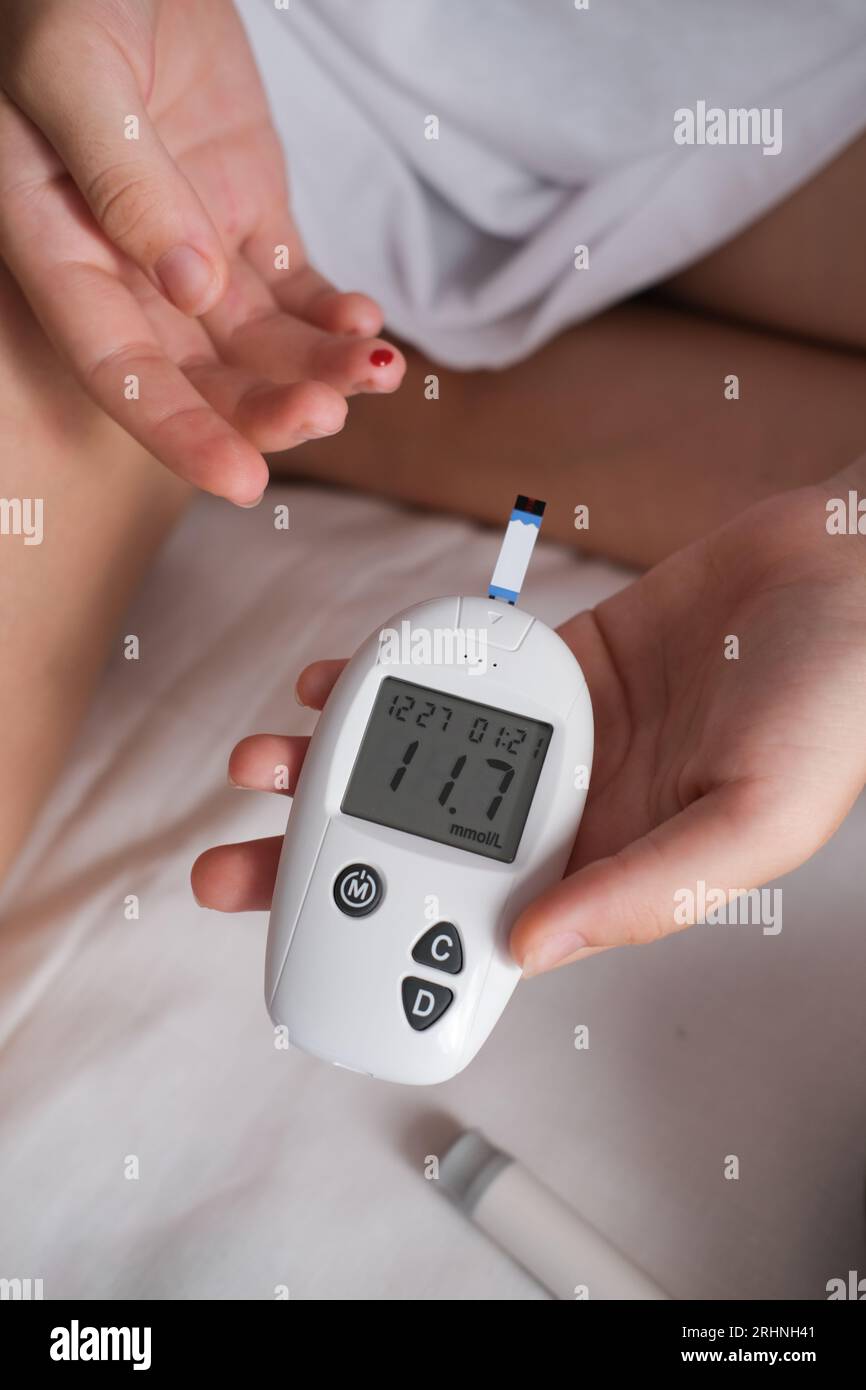 Diabetes test. Child hands checking blood sugar level by Glucose meter ...