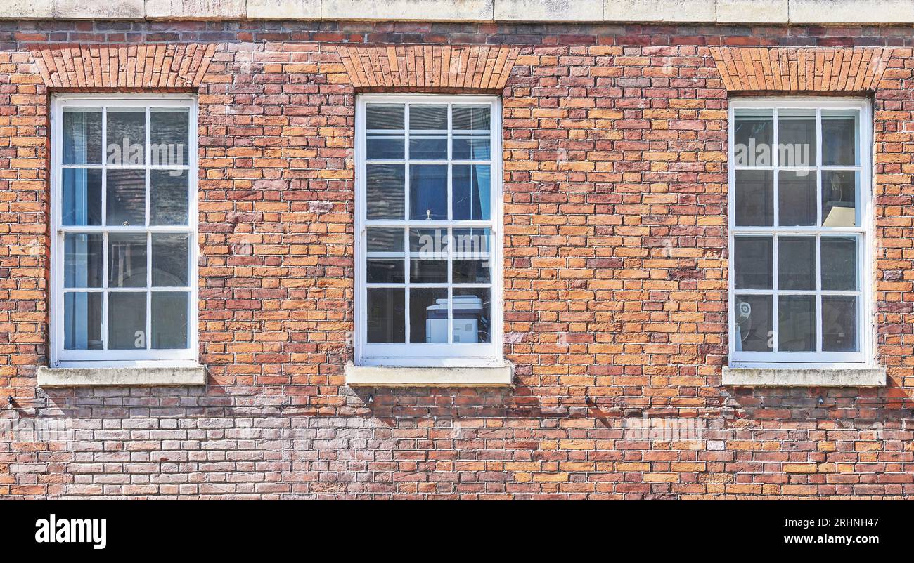 Three window on a brick wall at Pembroke College, founded in the 14th ...