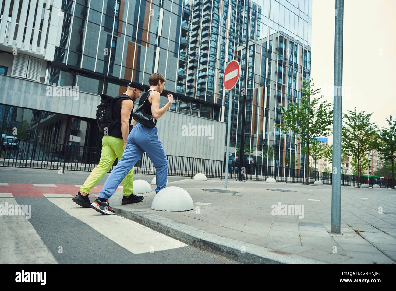 Young couple, talking, walks along a pedestrian crossing Stock Photo ...